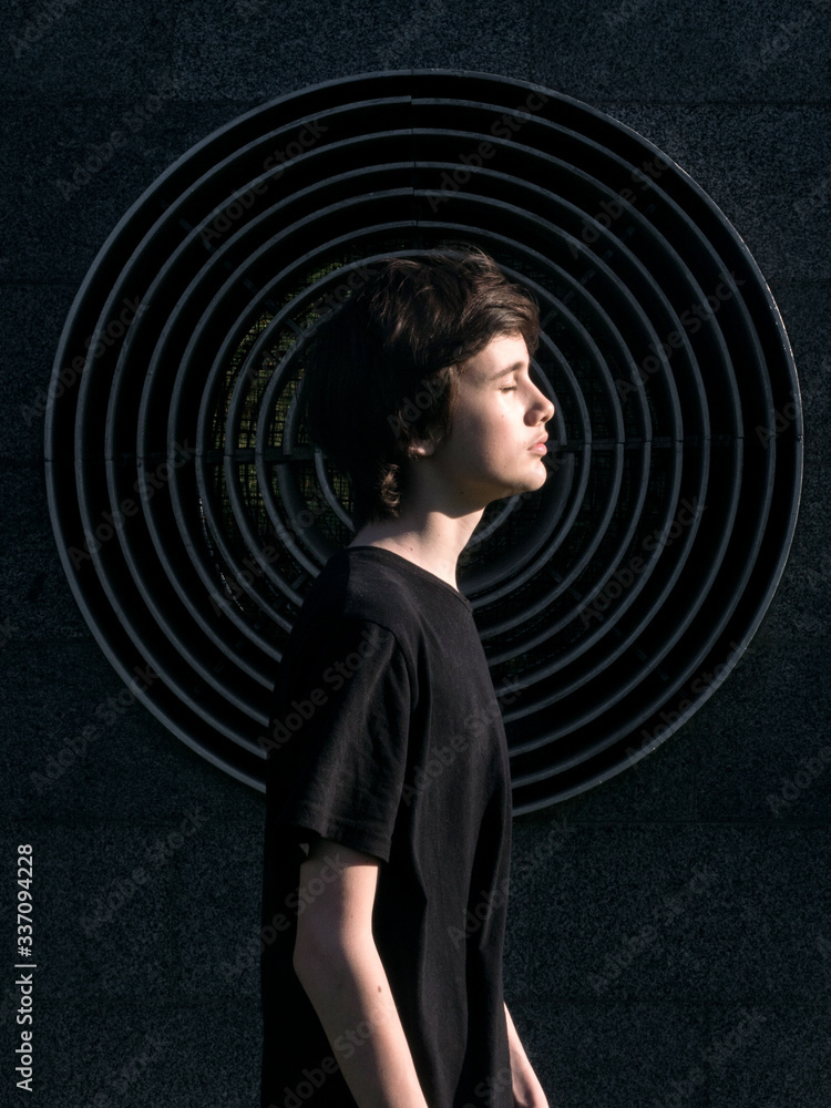 Side view of teenage boy standing outdoors Stock Photo | Adobe Stock