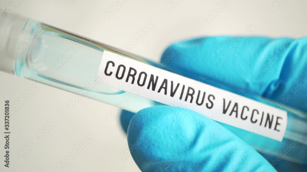 scientist holding test tube with covid-19 or coronavirus vaccine label ...