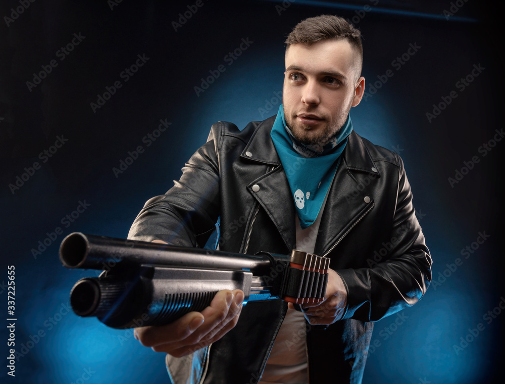 guy in a leather jacket with a shotgun Stock Photo | Adobe Stock