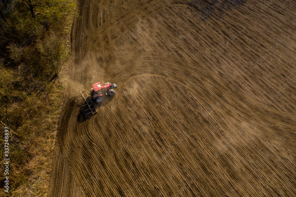 Farmer plowing the field. Cultivating tractor in the field. Red farm ...