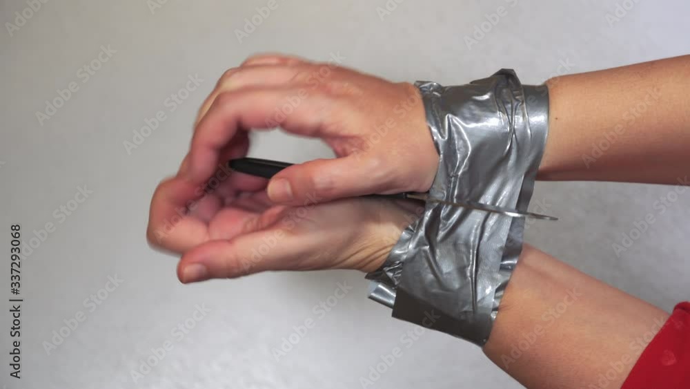 Trying to tear duct tape and escape from tied hands survival concept ...