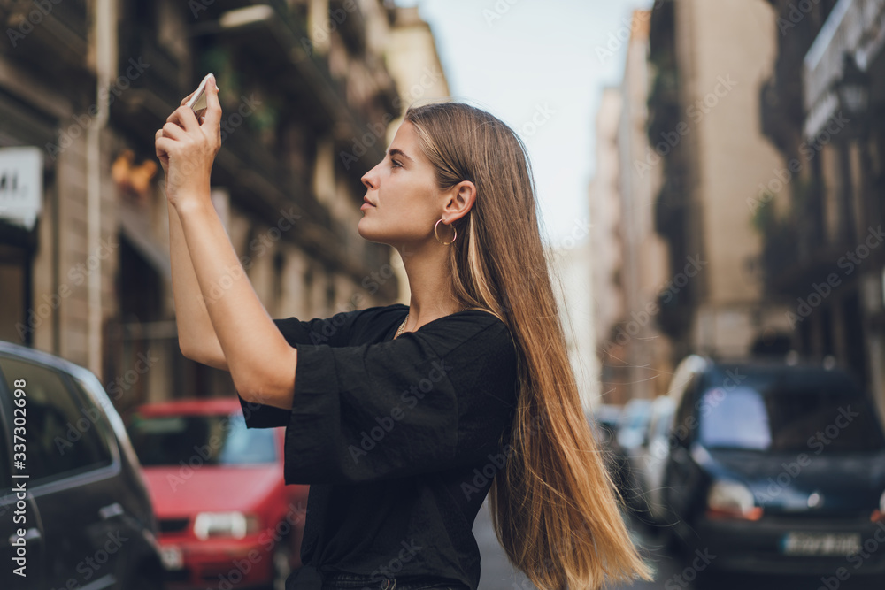 Girl makes selfie in front of a beautiful street. Selfies are popular ...