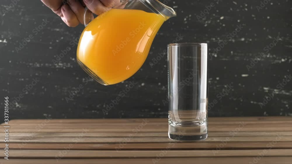 Orange juice being poured in tall glass. Healthy nutrition. Pouring ...