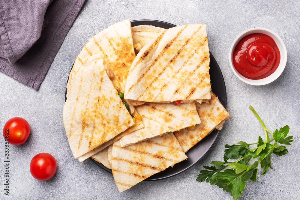 Triangular slices of a Mexican quesadilla with the sauce. The ...