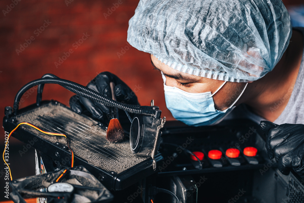 Young specialist cleans a computer with a brush, how to properly clean ...