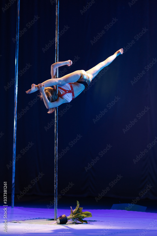 Girl athlete gymnast shows an acrobatic performance on a pylon. Stock ...