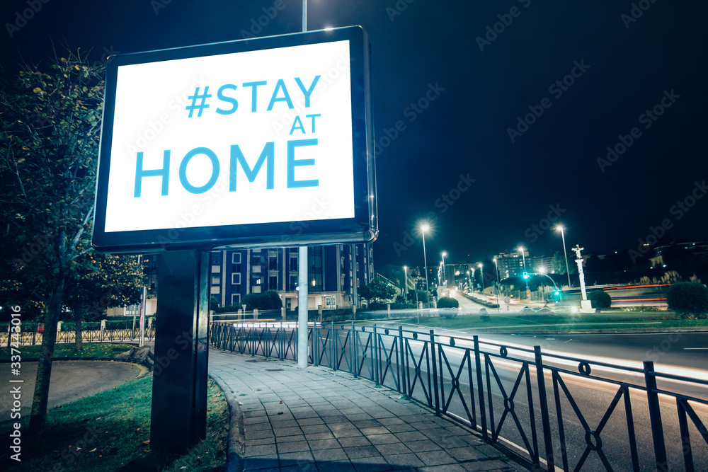 Stay at home campaign in square billboard screen on the street at night ...