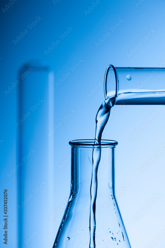 Test Tube Pouring Liquid In Flask Stock Photo | Adobe Stock