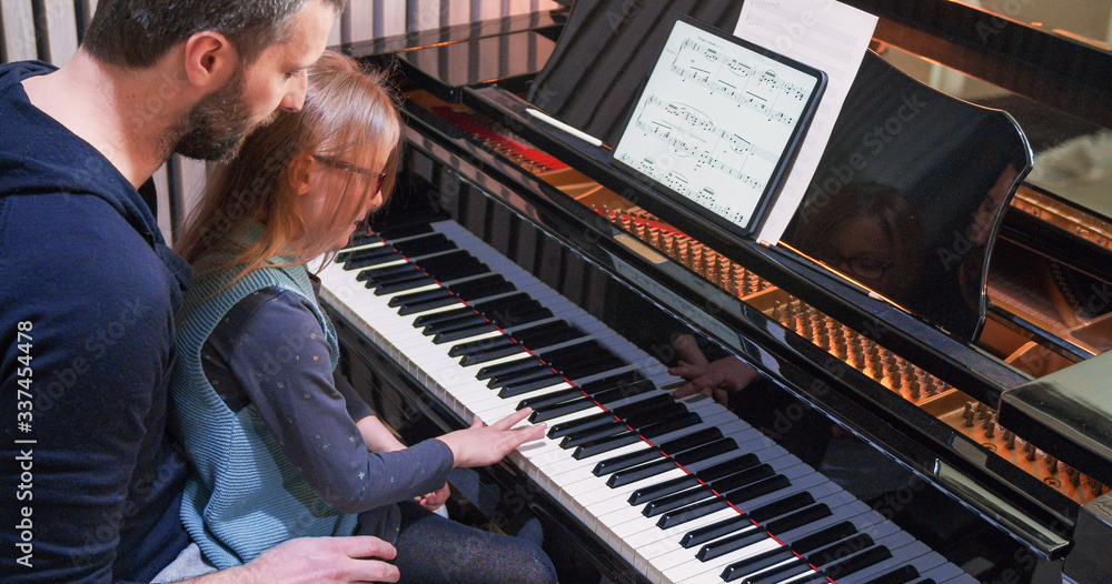 Dad teaching piano to his daughter.Little girl learning piano at home ...