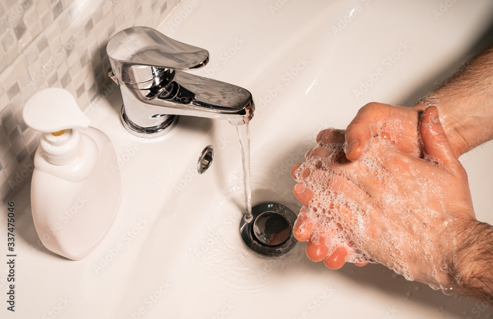 Hygiene concept. Washing hands with soap under the faucet with water ...