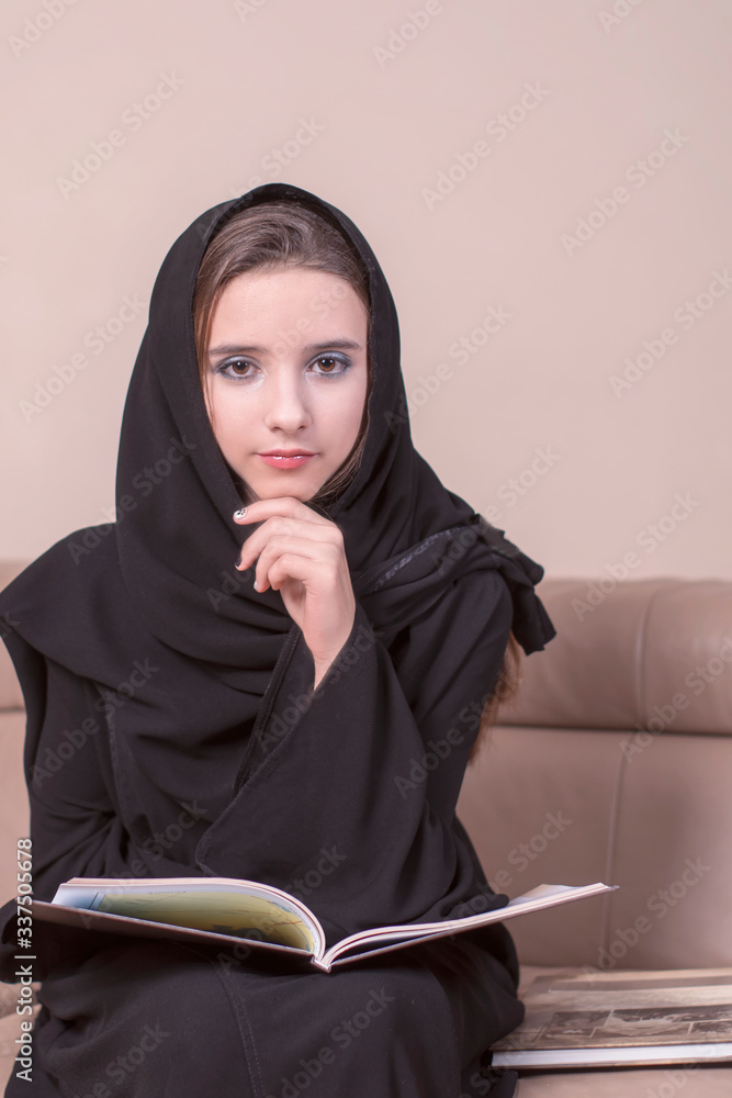Arabic student wearing abaya, holding book..Arab young girl dressed in ...