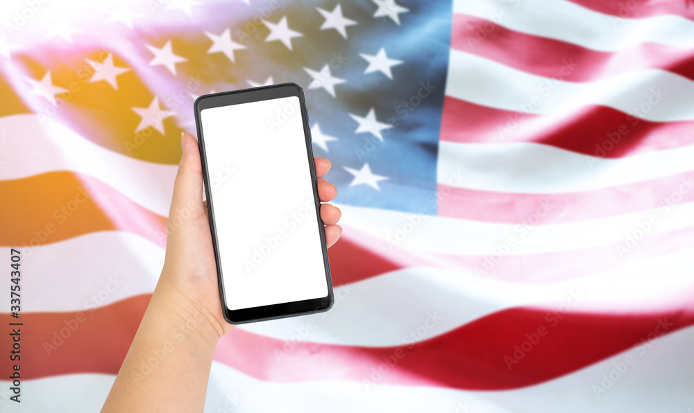 Hand holding mobile phone on crumpled of United states of America flag ...