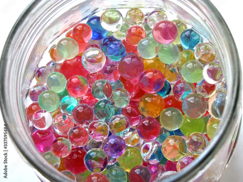 Orbeez multi-colored balls in a glass jar close-up. Colorful abstract ...