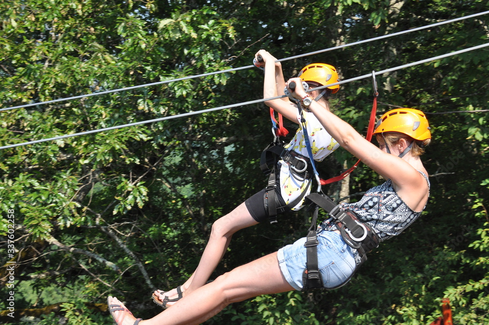 Mother and daughter riding down a zipline over the Tara Gorge, a river ...