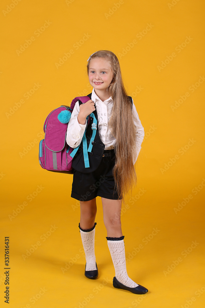 Portrait of a first-grader girl in a school uniform with long flowing ...