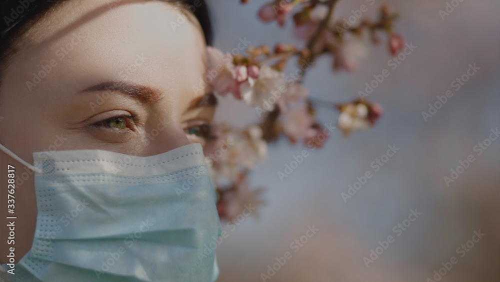 beautiful sad woman in surgical face mask looks away. Eye close view ...