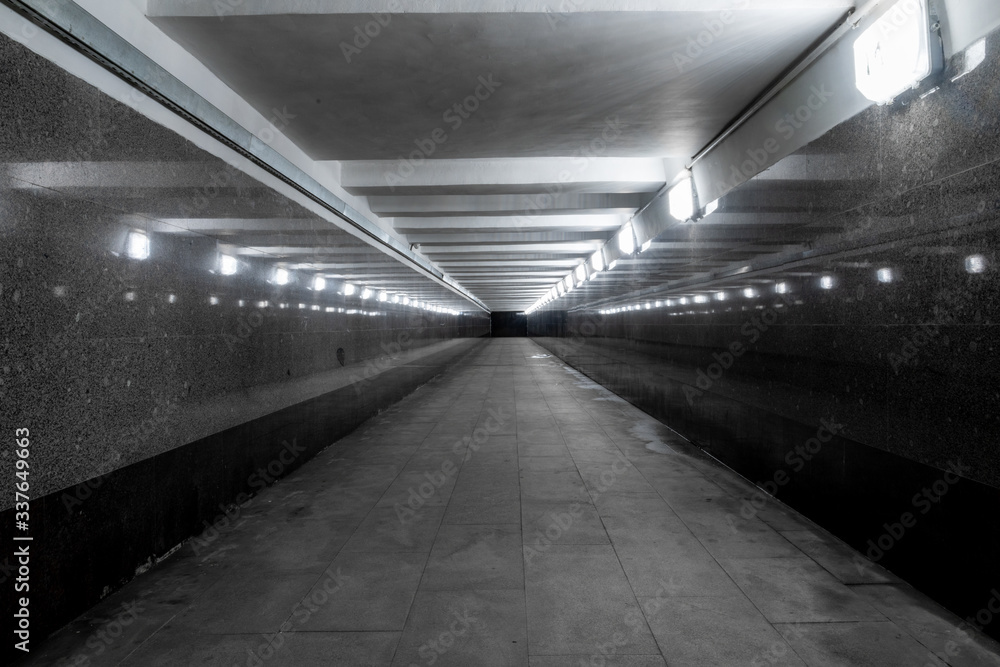 Underground pedestrian crossing. A long concrete tunnel in the city ...