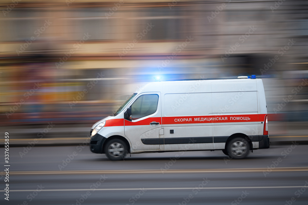Ambulance van racing through city street with motion blur. First ...