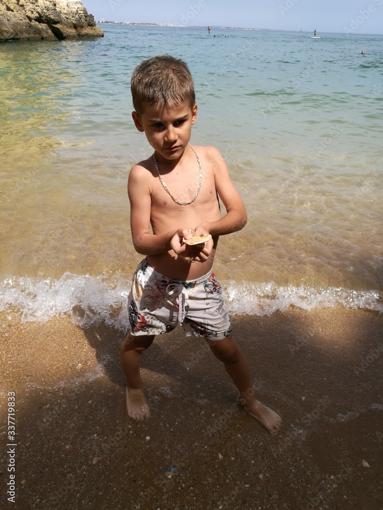 Full Length Of Shirtless Boy Standing On Beach Stock Photo | Adobe Stock