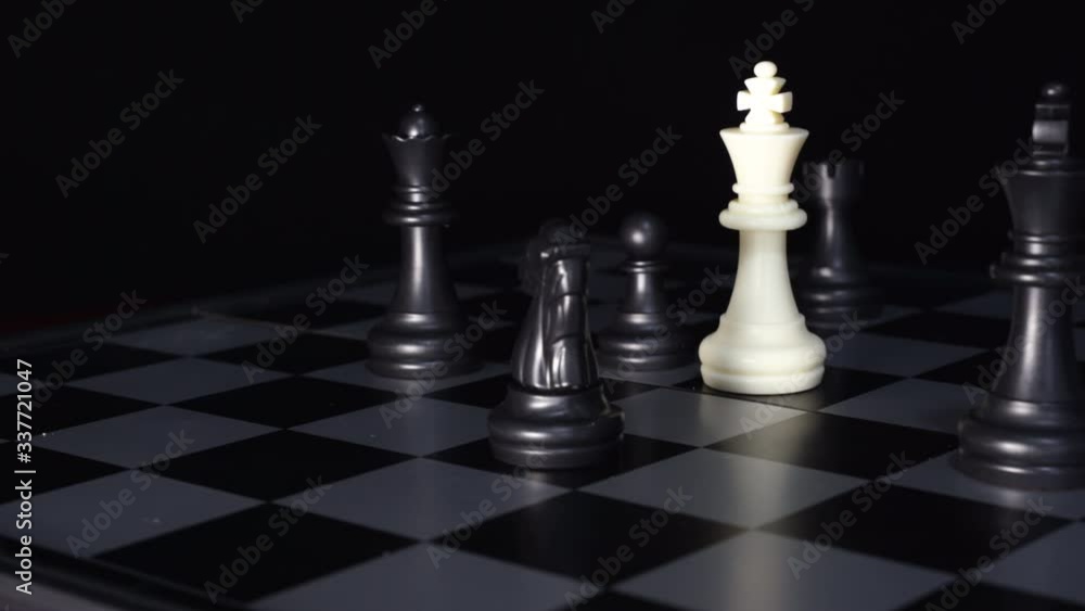 Board game of chess with white king surrounded by black pieces ...