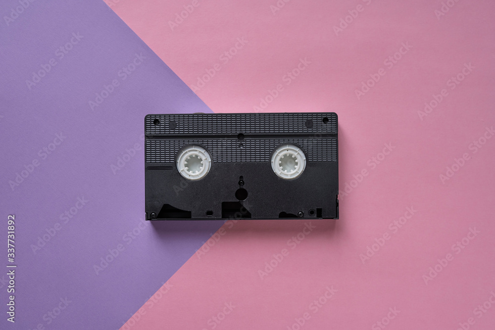 Top view of black VHS cassette on a pink and purple background. ภาพถ่าย ...