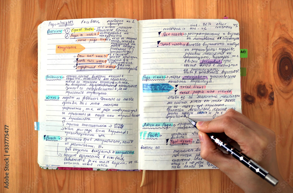 good student taking notes in a colorful marked and underlined school ...