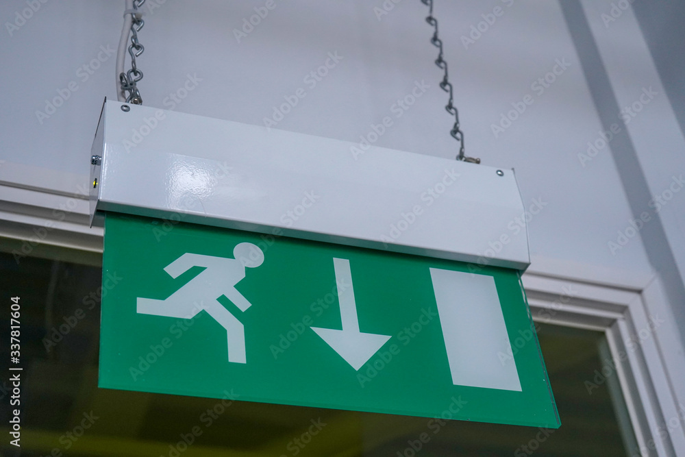 Emergency exit sign hanging on a wall Stock Photo | Adobe Stock