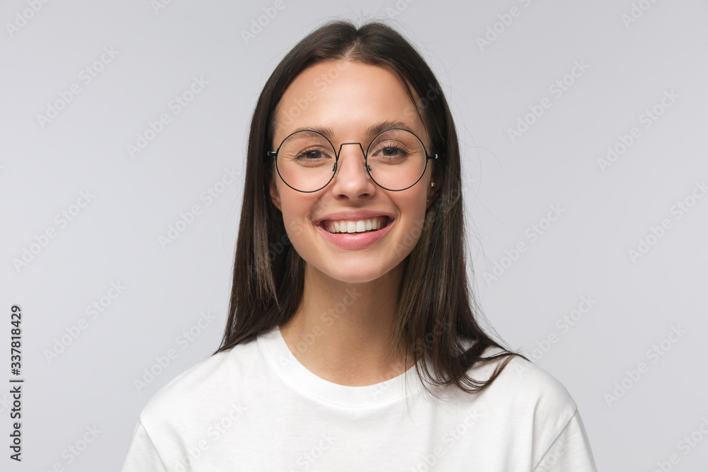 Young laughing woman wearing big round eyeglasses, smiling happily ...