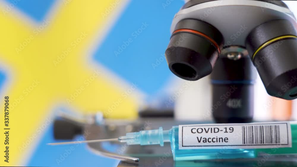The black lens of the microscope with the syringe for coronavirus ...