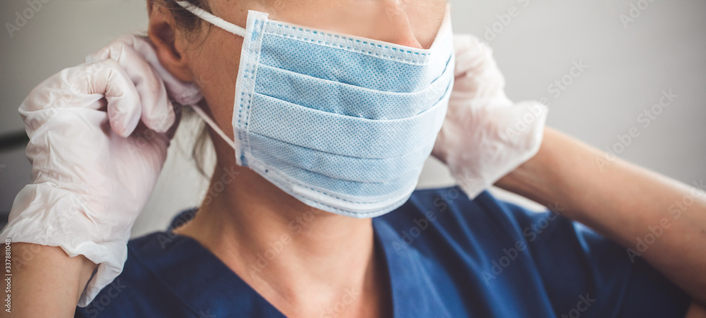 Doctor wearing protection face mask and latex gloves against ...