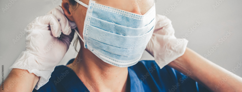 Doctor wearing protection face mask and latex gloves against ...