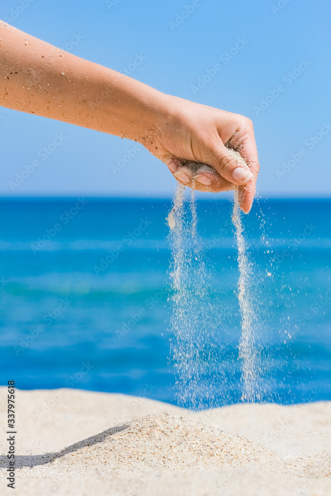 A Hands pour sand from the sea to nature on a journey. Vacations on the ...
