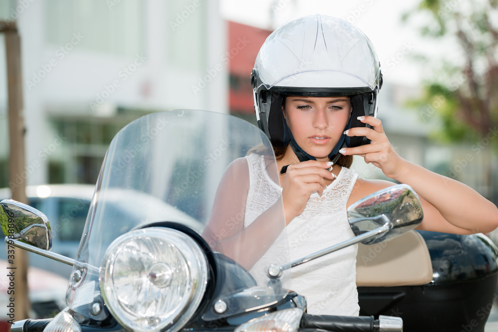 Young teenage girl sitting on the motorcycle with a hard hat on the ...