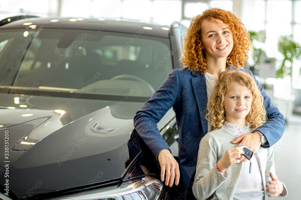 woman and child girl get the keys of their long awaited car. family ...