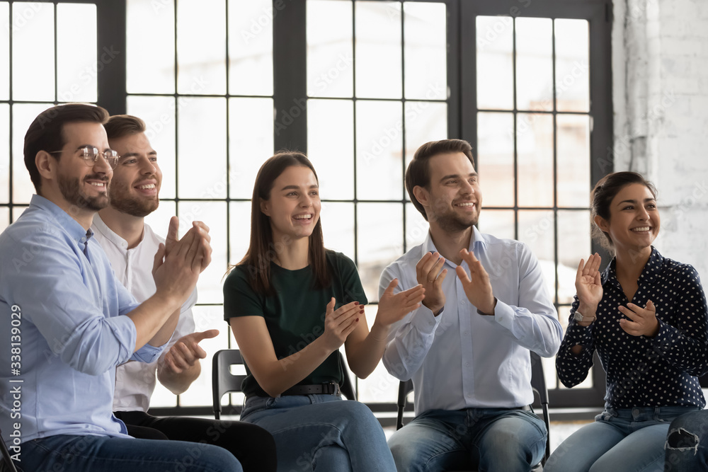 Overjoyed diverse young colleagues applaud celebrate victory or win at ...