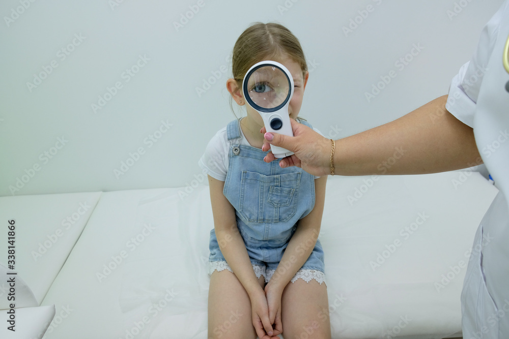 the girl at the doctor’s office sits on the couch and checks her vision ...
