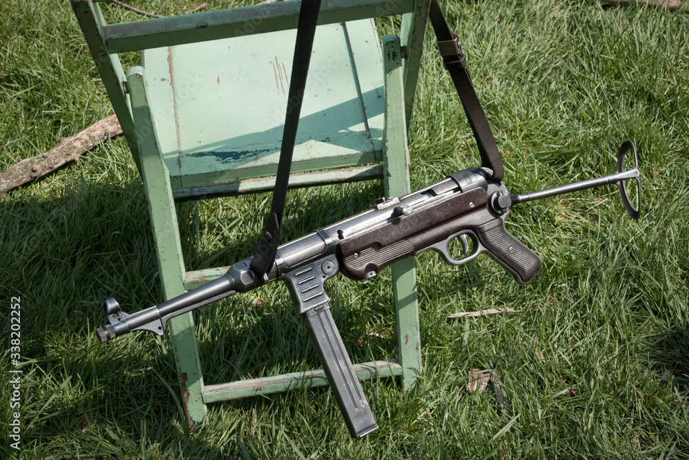 German WWII MP-40 9mm sub-mahine gun (pistol) slung over a wooden green ...