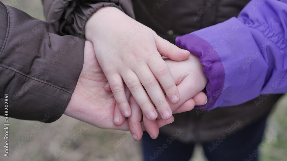 Hands of mother and children close-up putting their hands on each other ...