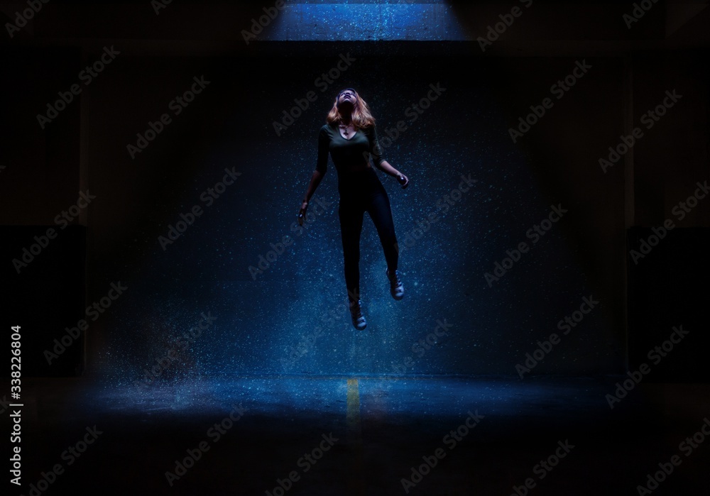 Full Length Of Young Woman Levitating In Darkroom Stock Photo | Adobe Stock