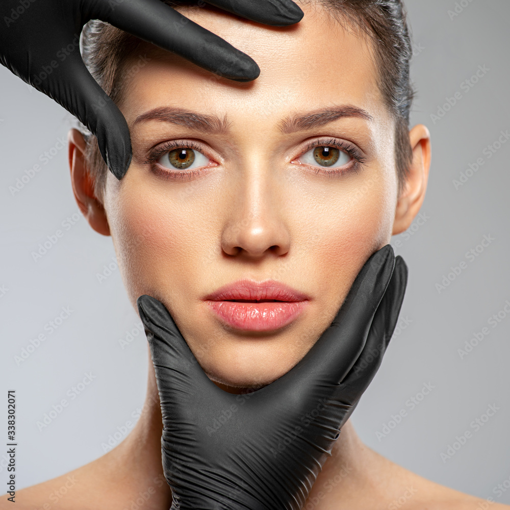 Plastic surgery doctor is touching face of a patient by hands. Face ...