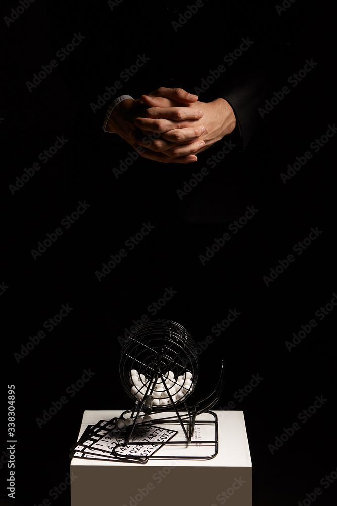 Staged photo of male hands with interlocked fingers over a bingo game ...