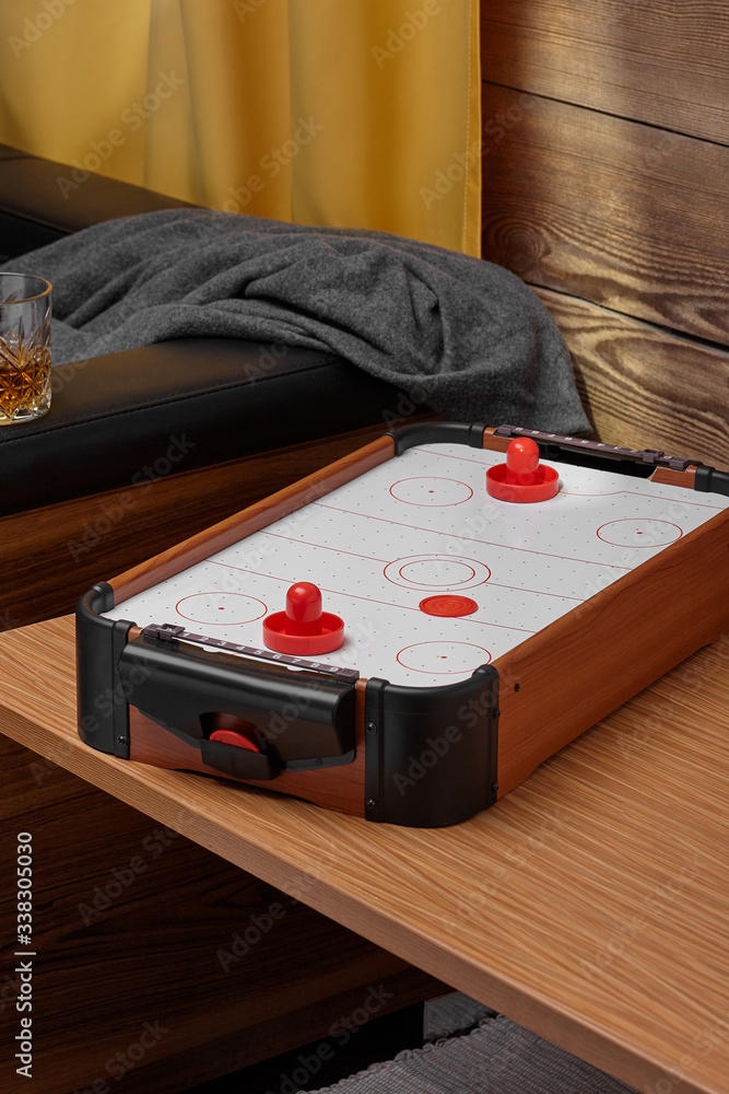 Staged photo of air hockey game on the bedside table and a couch with ...