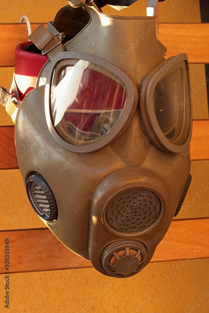 Military gas mask model M10 hanged on flower pot attached to wooden ...