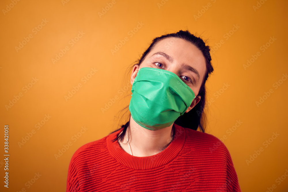 Girl in a green mask on an orange background. Stock Photo | Adobe Stock