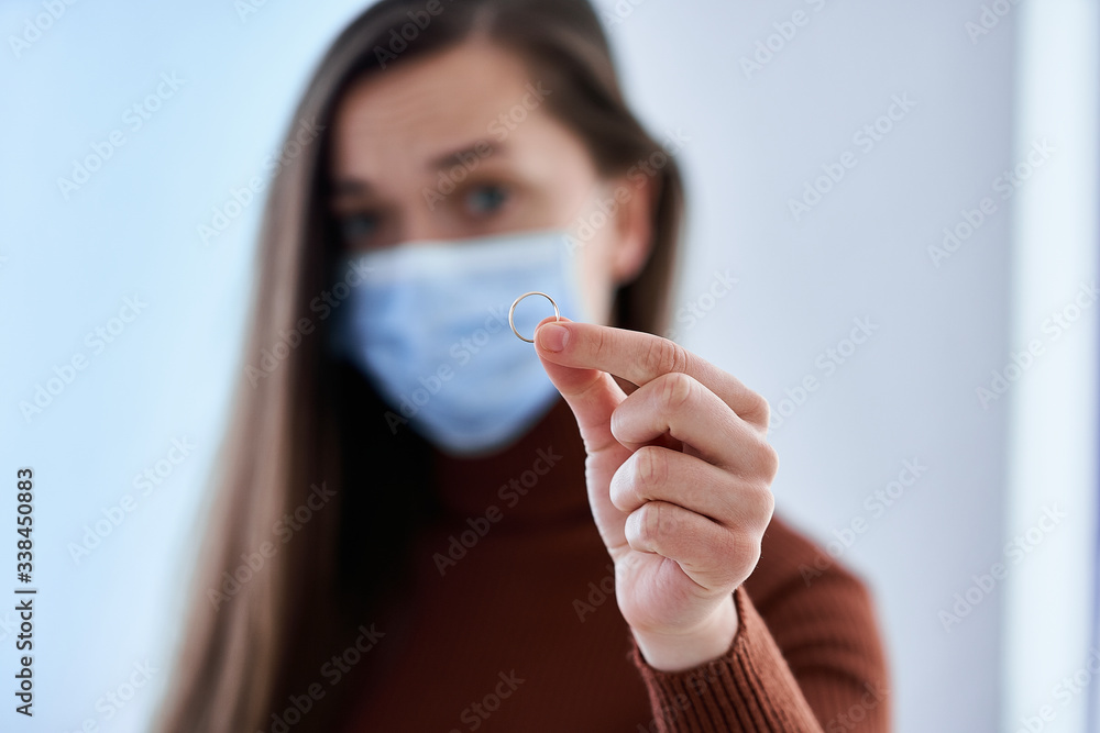 Woman in protective mask holds ring. Break up relationship after living ...