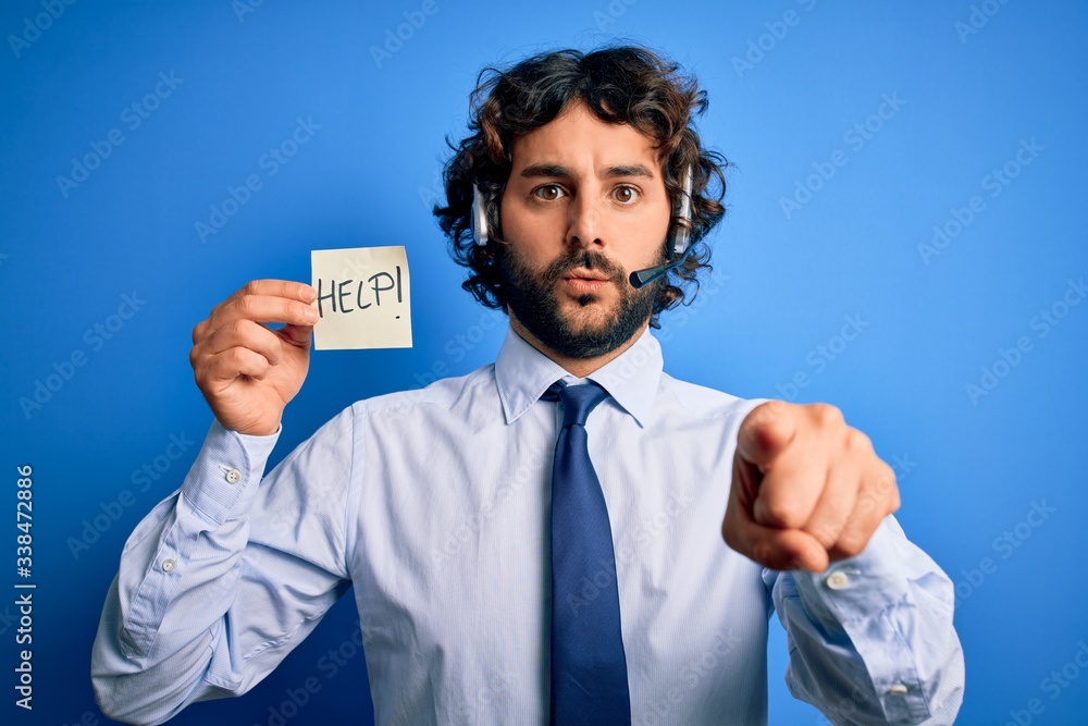 Young handsome call center agent man with beard working using headset ...