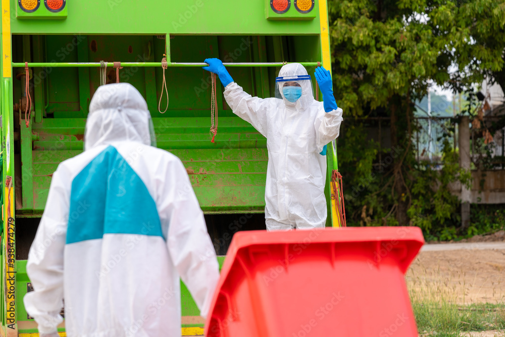 Two garbage men in hazmat PPE protective clothing wear medical rubber ...
