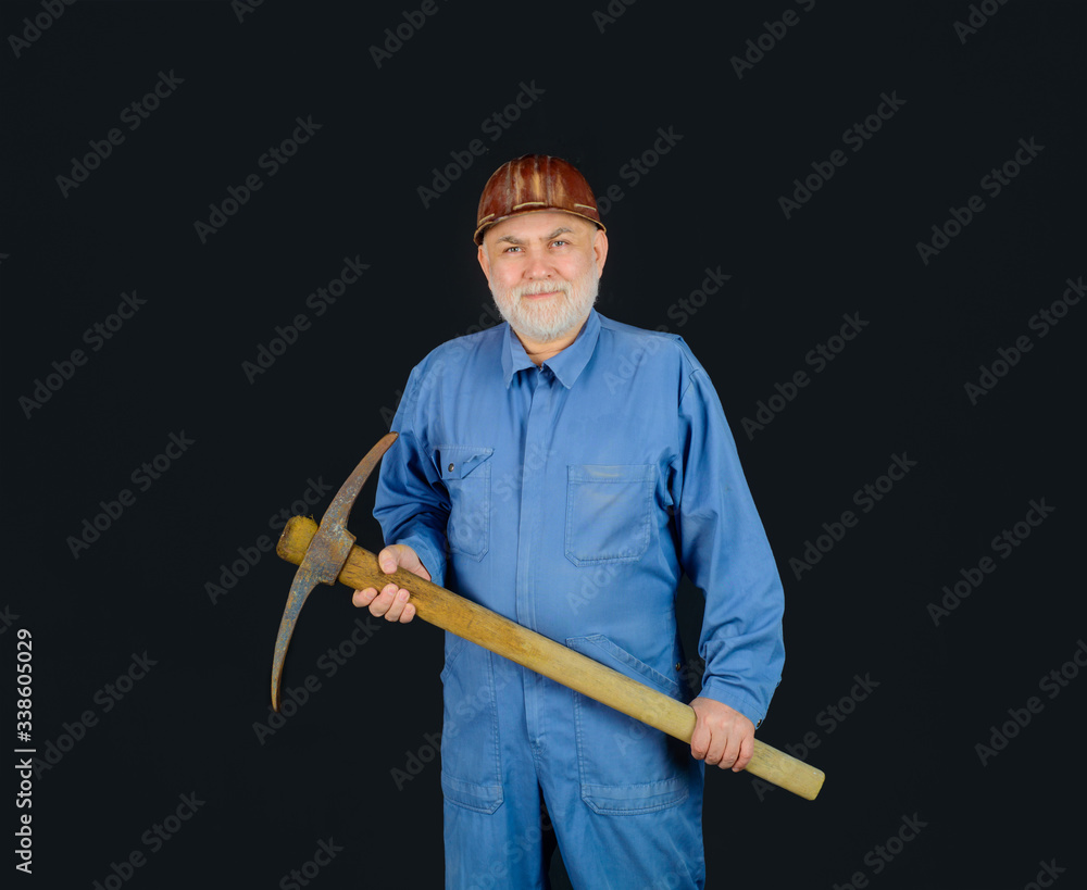 Smiling workman with pickaxe. Male bricklayer in hard hat with pickaxe ...
