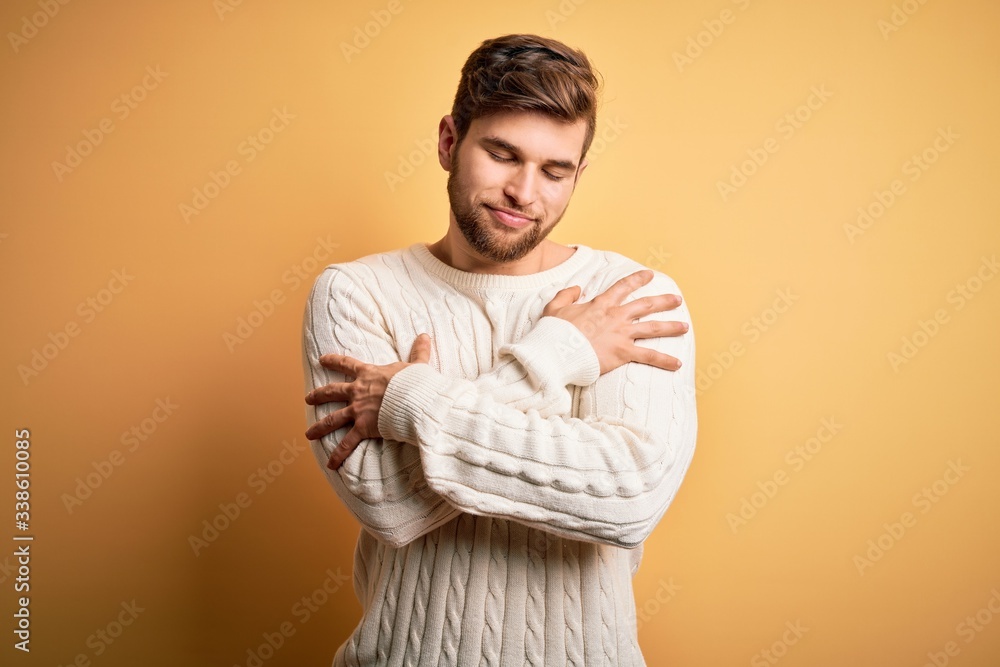 Young blond man with beard and blue eyes wearing white sweater over ...