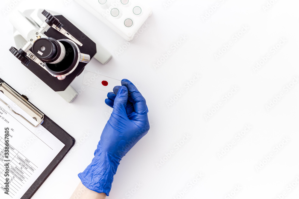 Bood testing with microscope in laboratory. Sample in hands on white ...